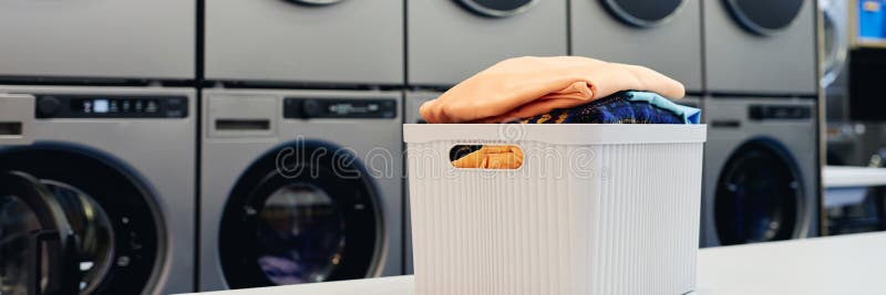 Header Image of Laundry Basket with Colored Clothes on Table at Public ...