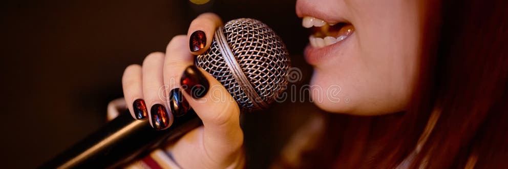 Header Image of Microphone in Hands of Young Female Vocalist Performing ...