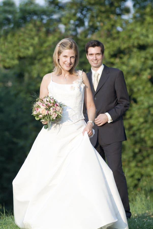 Wedding Couple in Front of Church Stock Image - Image of woman, bouquet ...