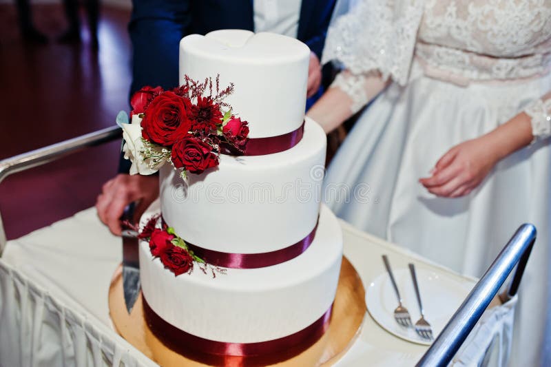 Wedding Couple Cut Wedding Cake with Red Roses and Ribbon Stock Photo ...