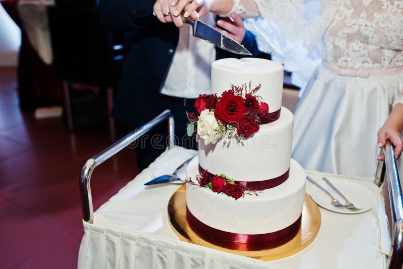 Wedding Couple Cut Wedding Cake with Red Roses and Ribbon Stock Photo ...