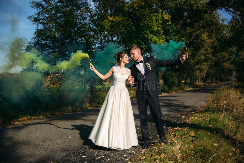 Wedding Couple Hold Colored Smoke in Their Hands in the Middle of Alley ...