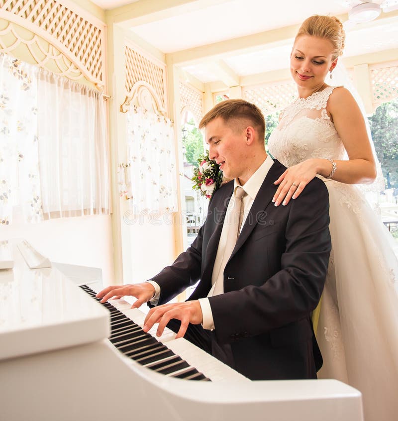 Wedding Couple Playing on a Piano in the Room Stock Photo - Image of ...