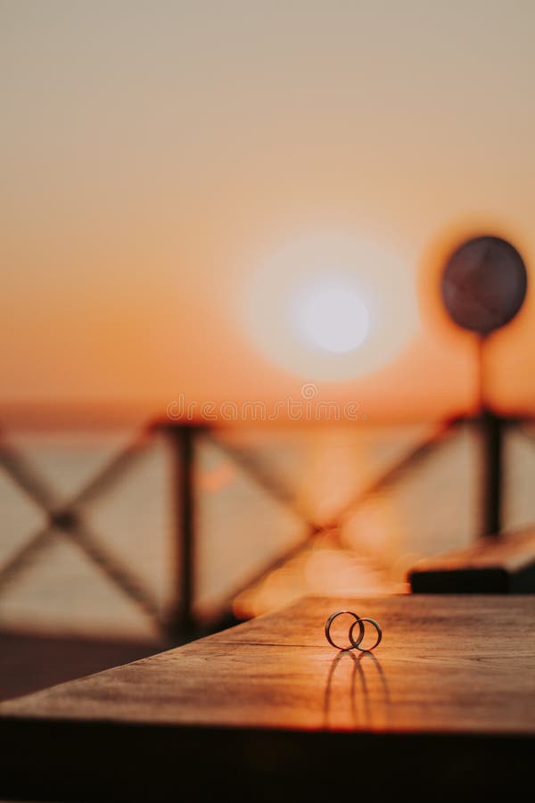 Wedding Rings on a Beautiful Wooden Texture Surface Against the Sunset ...