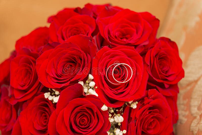2 Wedding Rings on a Bouquet of Red Roses Stock Image - Image of ...