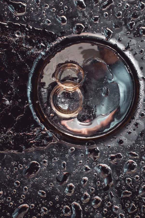Wedding Rings on a Chrome Plated Surface. Water Drops with Reflections ...