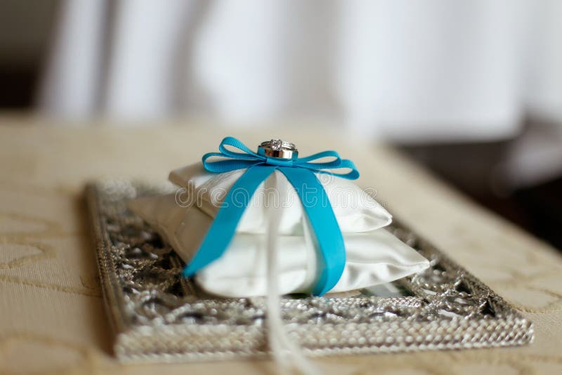 Wedding Rings on a Cushion with Blue Ribbon Stock Image - Image of ...