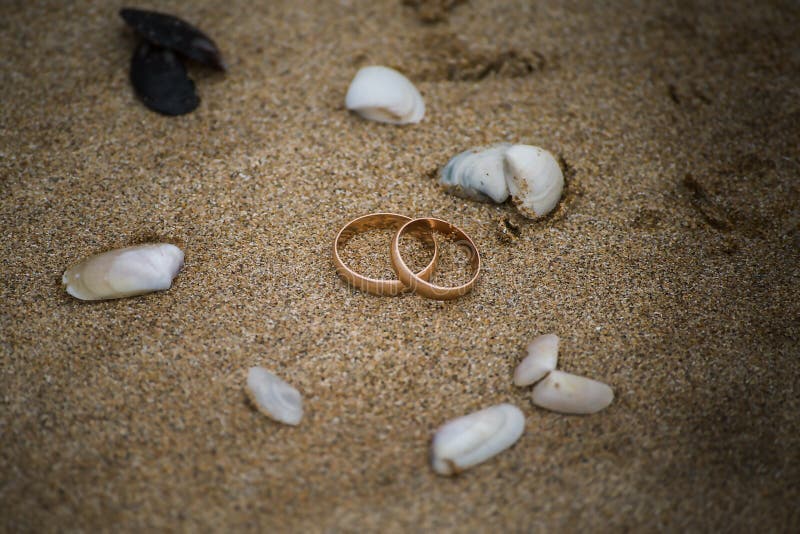 Wedding rings in the sand stock image. Image of closeup - 189007845