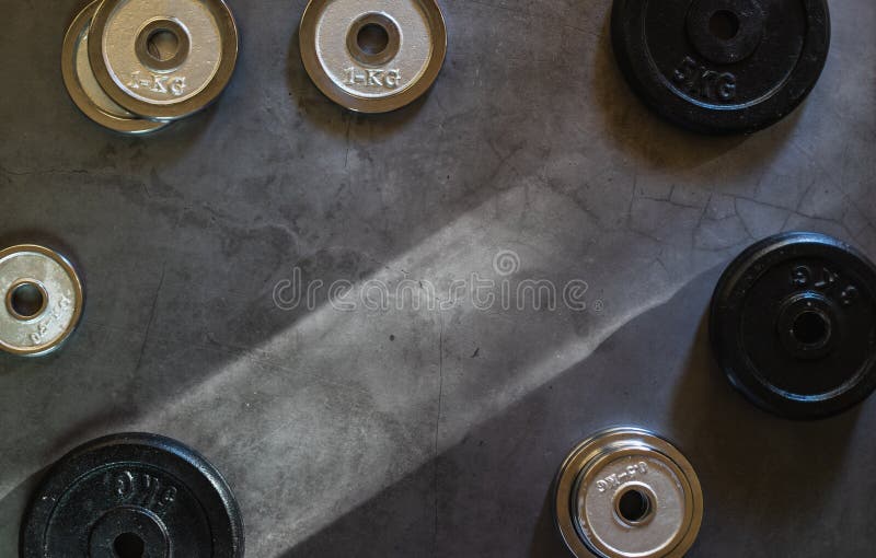 Weight Plates of Different Weights, Sizes and Colors on a Concrete ...