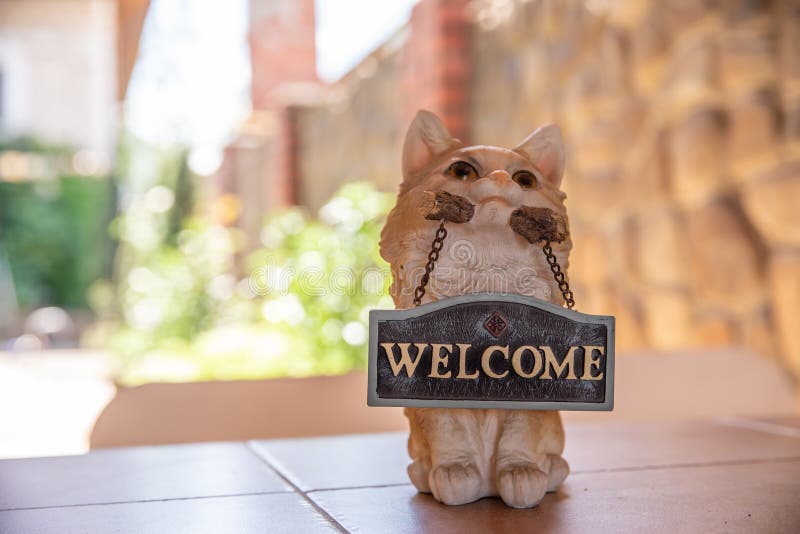 WELCOME . a Sign with the Inscription Welcome. Clay Cat Holds a Sign ...