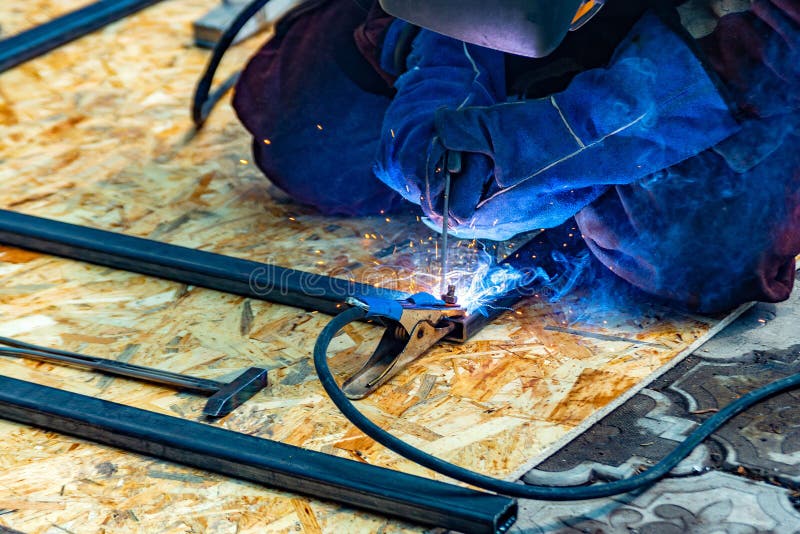 A Welder Assembles a Frame from a Metal Structure by Connecting it with ...