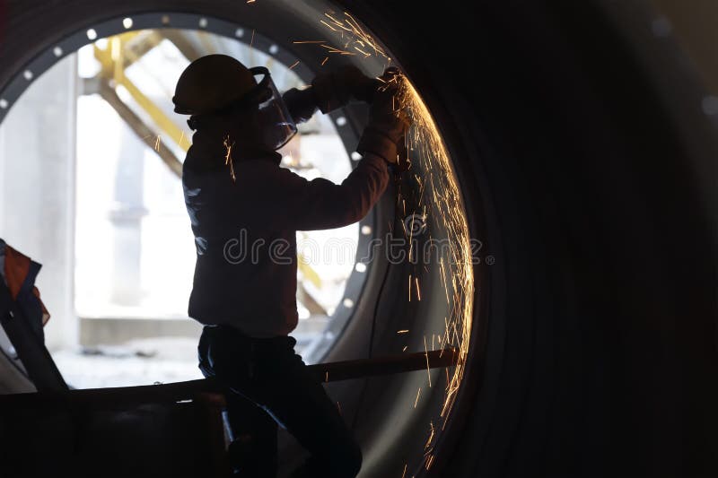 Welder is Grinding the Welding of Large Pipe. Grinding is an Abrasive ...