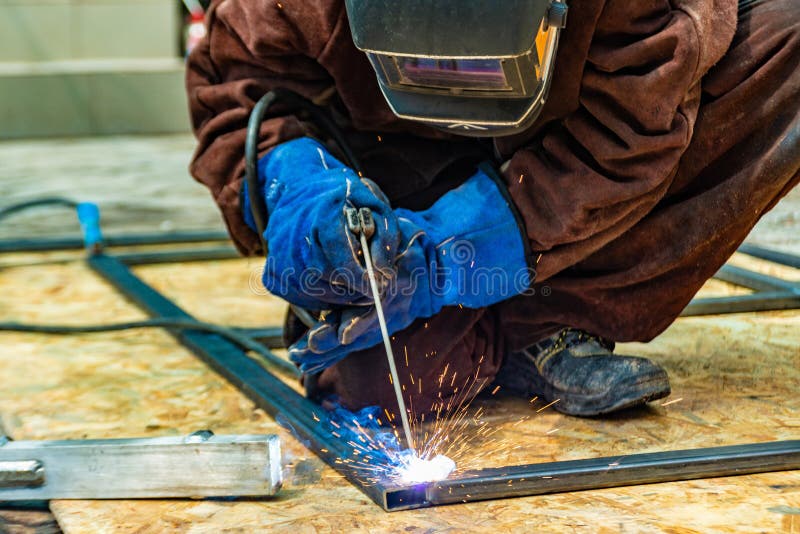 A Welder Makes a Frame from a Profile Pipe by Connecting Them with ...