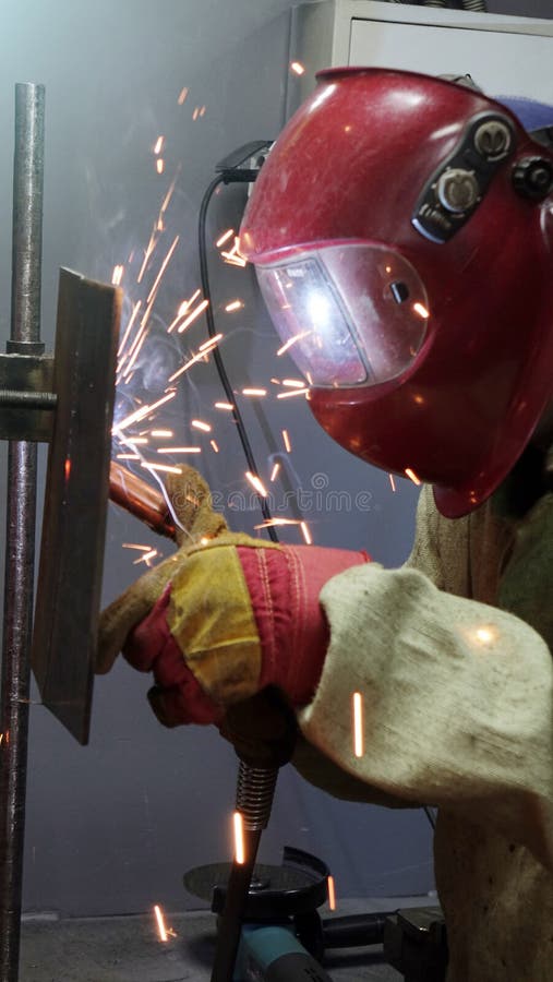 Welder in the Mask. the Metal Product is Welded by Welding Machine ...