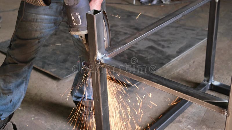Welder Processes the Welding Seams with an Angle Grinder, Sparks Fly ...