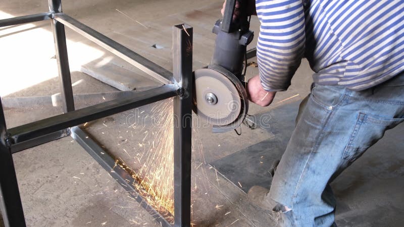 Welder Processes the Welding Seams with an Angle Grinder, Sparks Fly ...