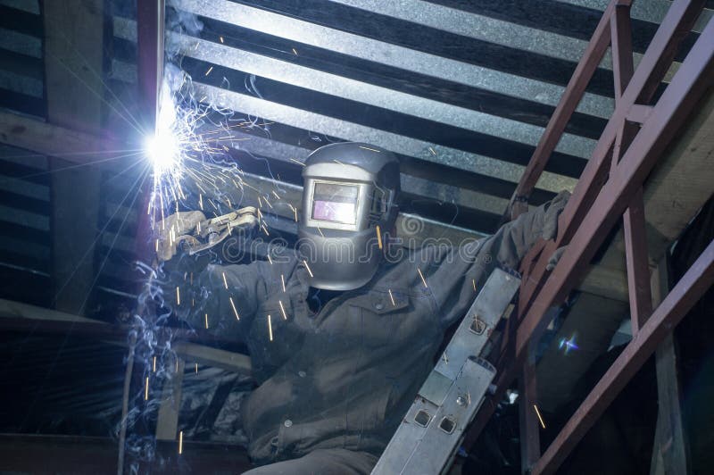 The Welder Produces Welded Work Indoors at Height Stock Image - Image ...