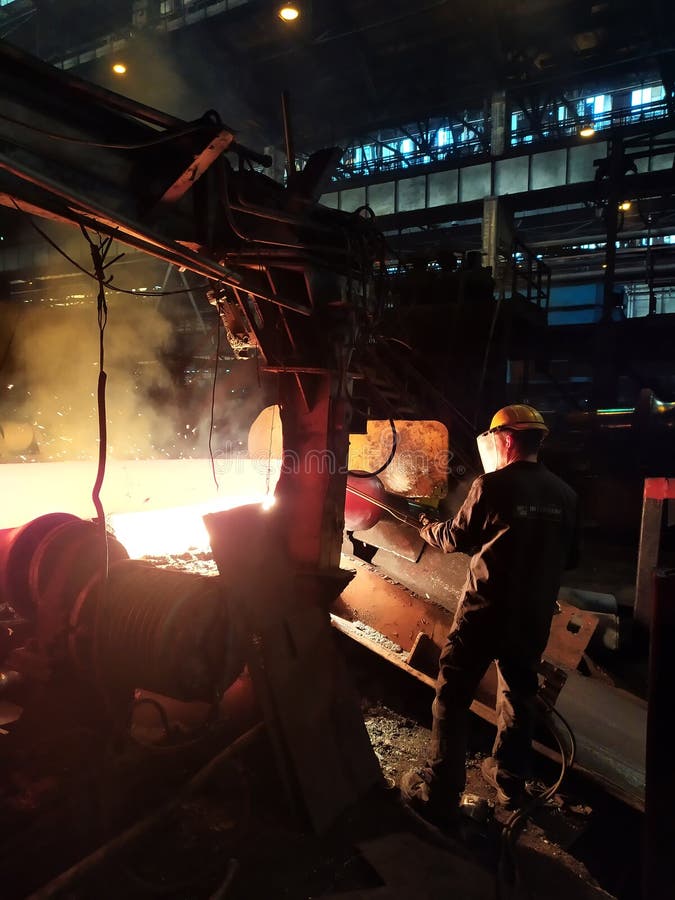 Welder in Protective Uniforms and Masks at the Pipe Mill. Metallurgy ...