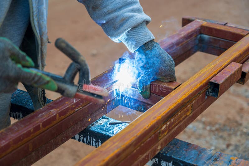 Welder Welding Two Iron Profiles at the Construction Site on a Sunny ...