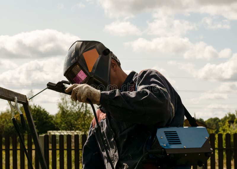A Welder Welds Metal Using a Welding Machine. Metal Work on the ...