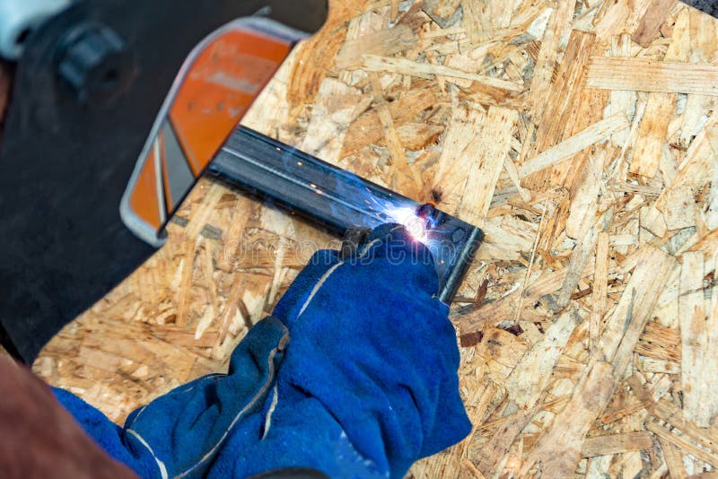 A Welder at Work Assembles a Metal Structure from a Shaped Pipe Stock ...