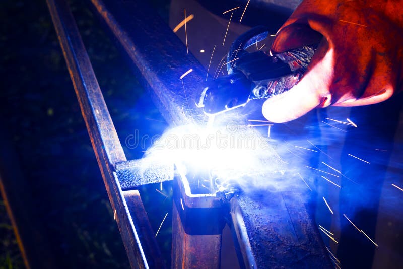 Welder Worker Performs Jump Welding. Man Welder in Protective Gloves ...