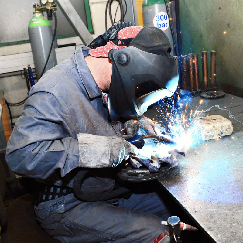 Welder at a Workplace in Metal Construction Working on a Workpiece Made ...