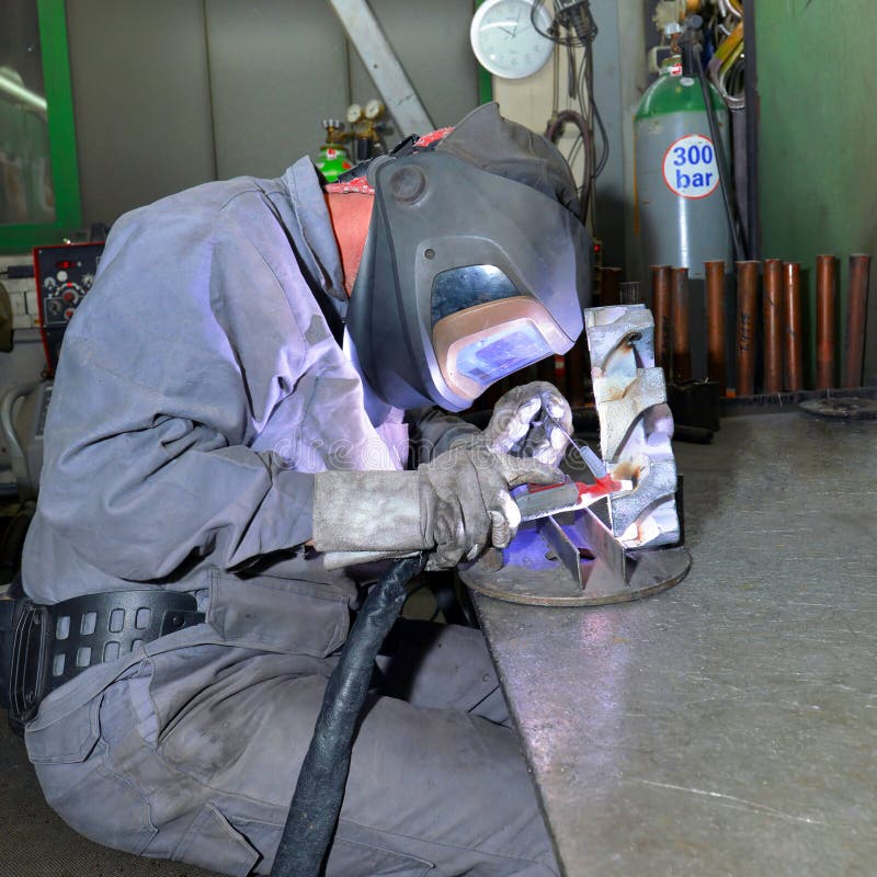 Welder at a Workplace in Metal Construction Working on a Workpiece Made ...
