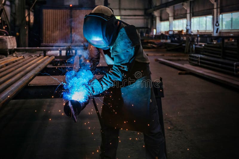 The Welder Works in the Workshop. the Moment of Welding of Metal ...