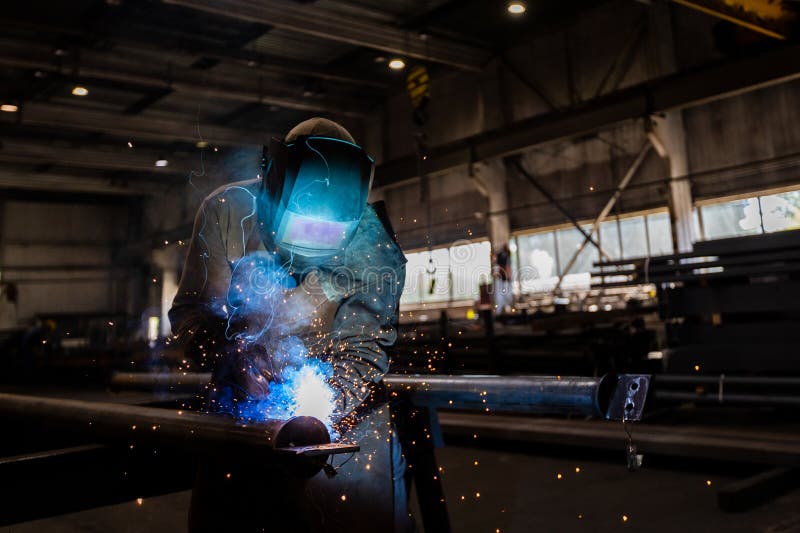 The Welder Works in the Workshop. the Moment of Welding of Metal ...