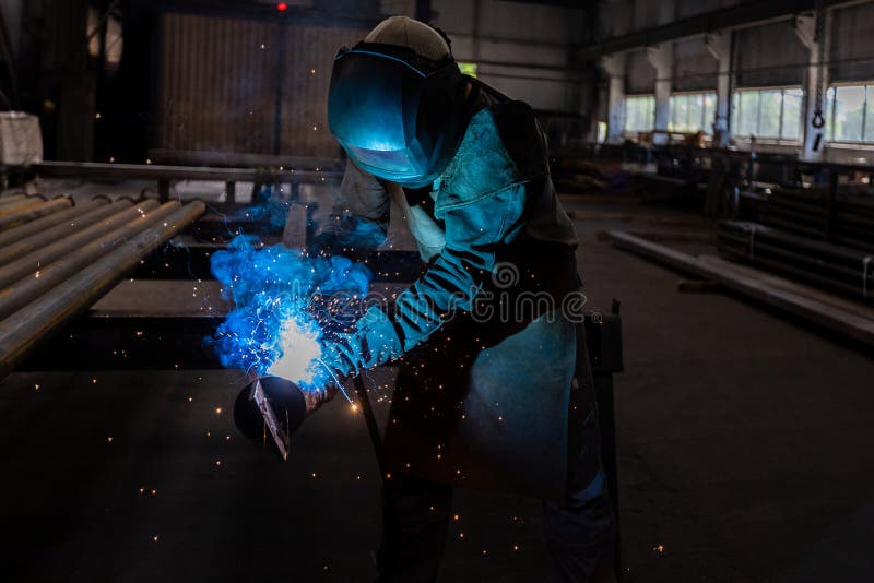 The Welder Works in the Workshop. the Moment of Welding of Metal ...