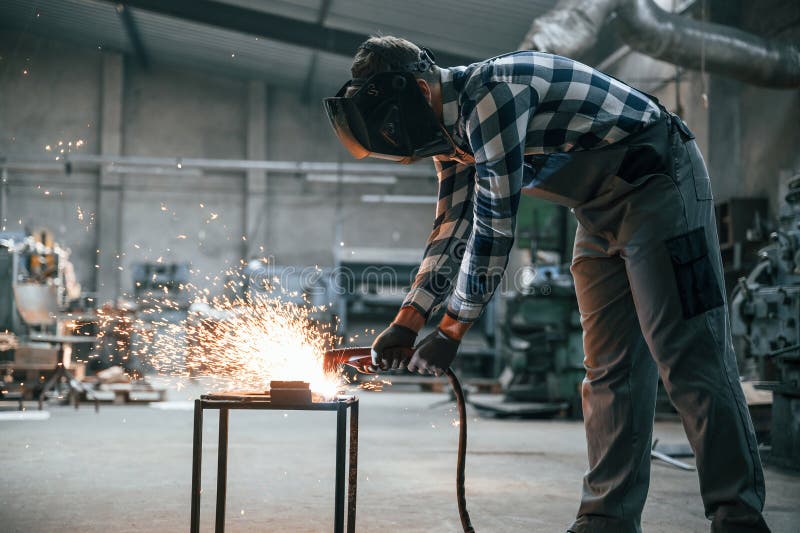 Welding of the Iron. Factory Male Worker in Uniform is Indoors Stock ...