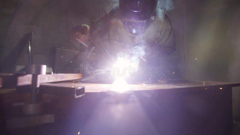 Metalworker Using Welding Machine on Iron Surface, Smoke, Sparks and ...