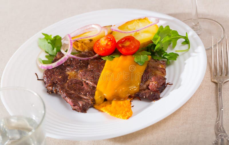 Well-cooked Beef Steak with Cheese and Baked Potatoes Served at Plate ...