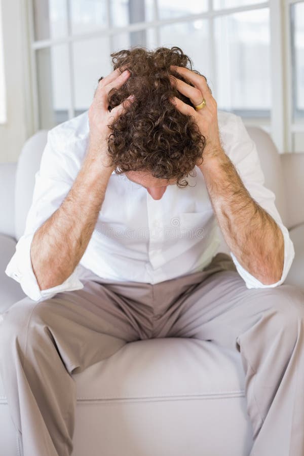 Worried Well Dressed Man Sitting with Head in Hands on Sofa in the ... Worried Well Dressed Man Sitting with Head in Hands on Sofa in the ...