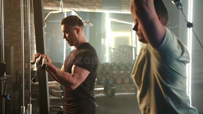 Two Men Engaging in Cable Crossover Machine for Arm and Back Workout ...