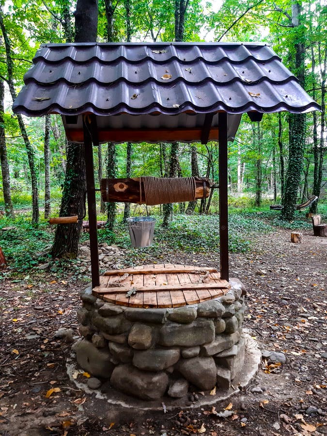 Old Well in the Forest with a Bucket on a Chain with a Broken Fence in ...