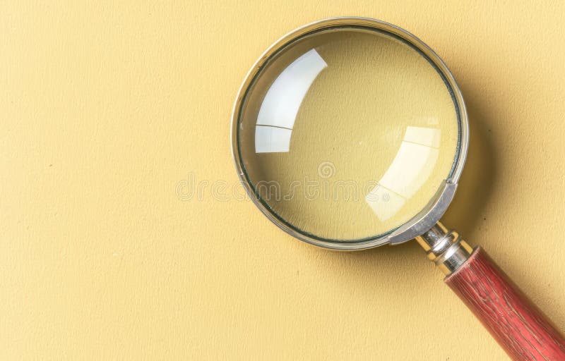 In a Well-lit Environment, a Magnifying Glass Rests on a Bright Yellow ...