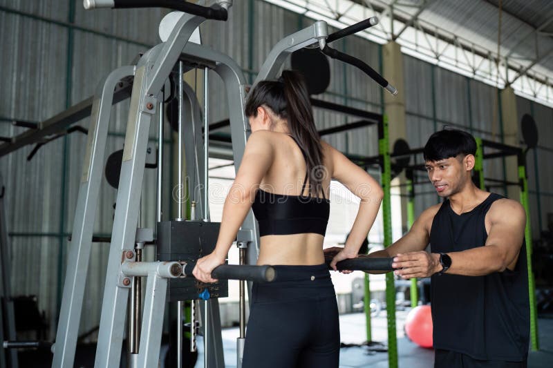 Wellness and Fitness. Personal Trainer Guiding Client through Pull-up Exercise. Stock Photo ...
