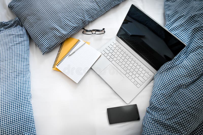 WFH - Work from Home Laptop, Notepad and Phone on Bed 1 Stock Photo ...
