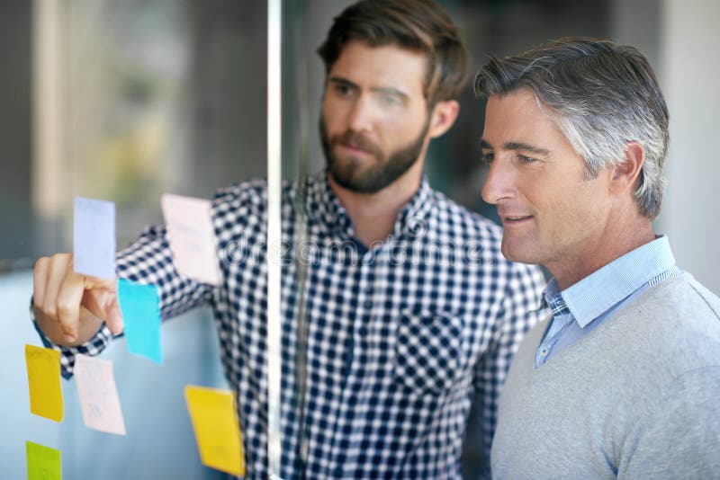 What is this. Coworkers Arranging Sticky Notes on a Glass Wall during a ...