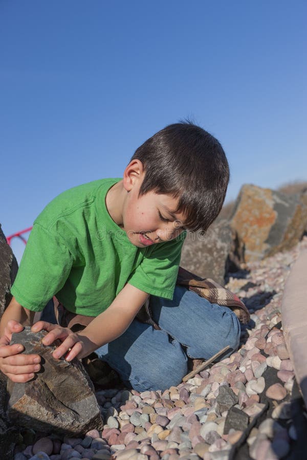 Boy looks under a rock. stock photo. Image of lifestyles - 51800882