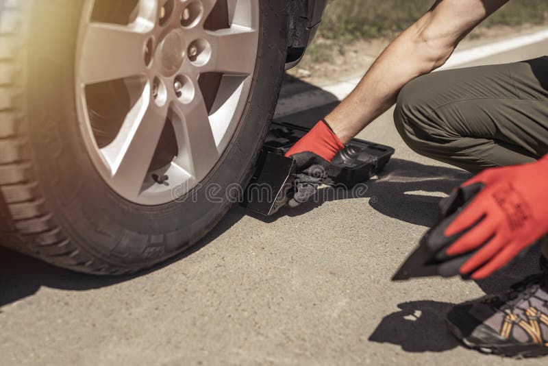 Wheel Chocks Under Car Tyre on Road, Man Drivers Hands Stock Photo ...