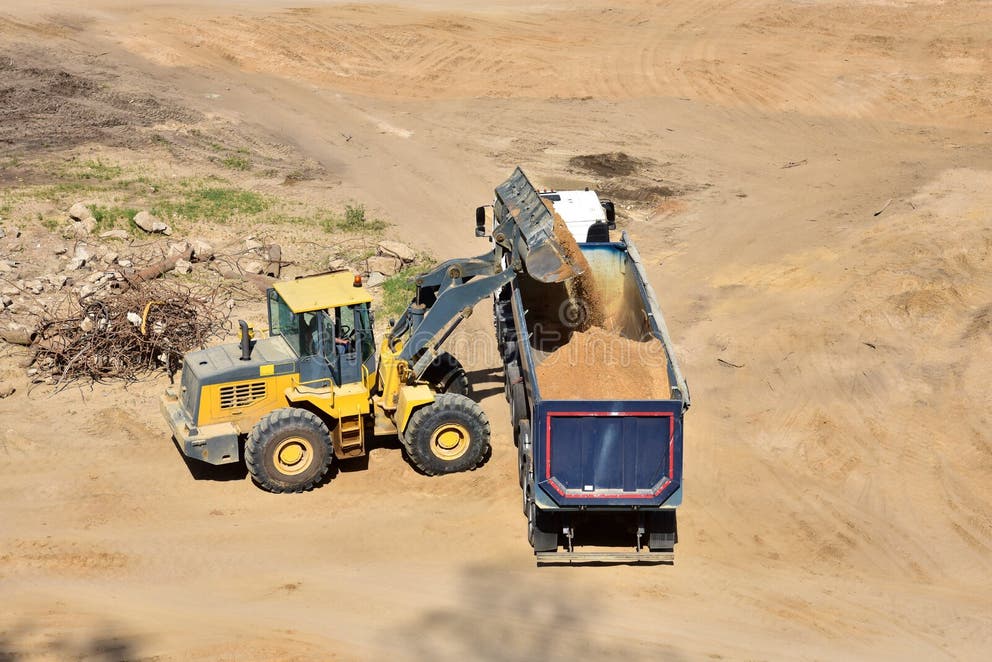 Wheel Front-end Loader Loading Sand into Heavy Dump Truck at the ...