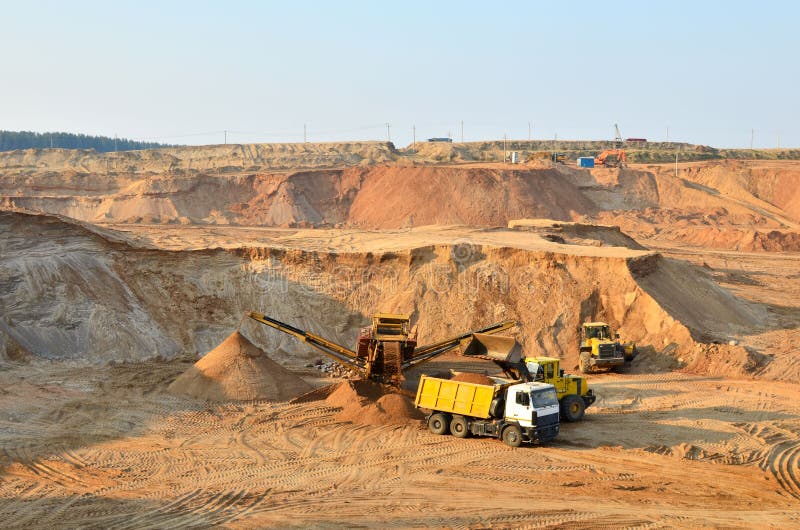 Wheel Front-end Loader Unloading Sand into Heavy Dump Truck. Crushing ...