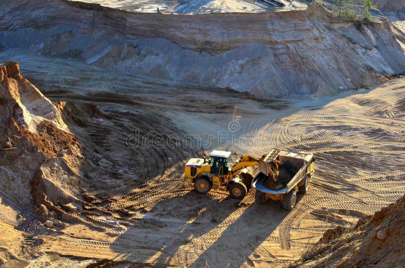 Wheel Front-end Loader Unloading Sand into Heavy Dump Truck at the ...