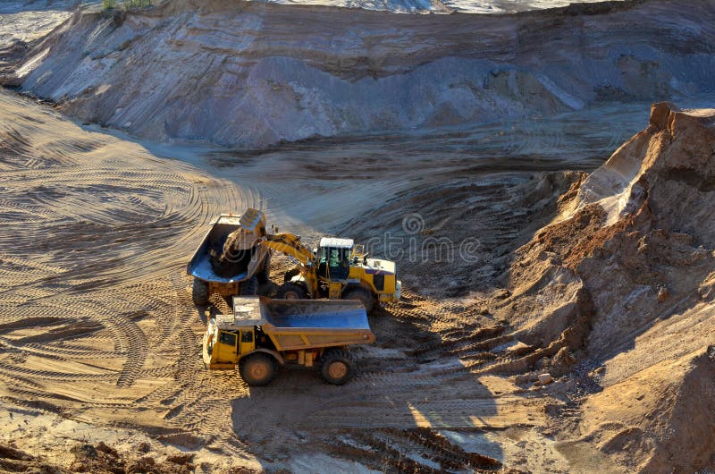 Wheel Front-end Loader Unloading Sand into Heavy Dump Truck at the ...