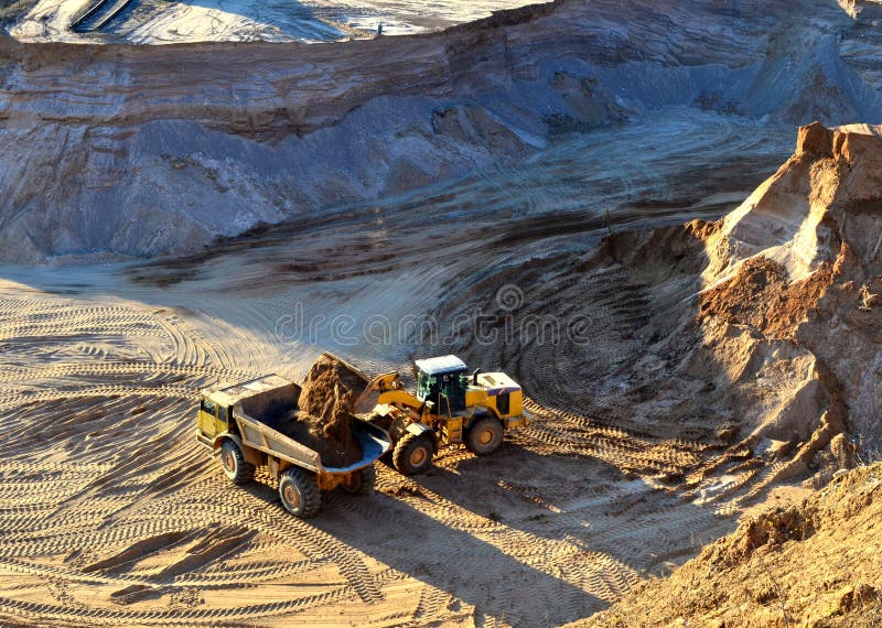 Wheel Front-end Loader Unloading Sand into Heavy Dump Truck at the ...