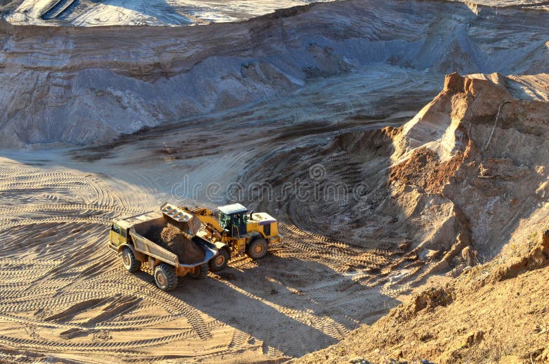 Wheel Front-end Loader Unloading Sand into Heavy Dump Truck at the ...