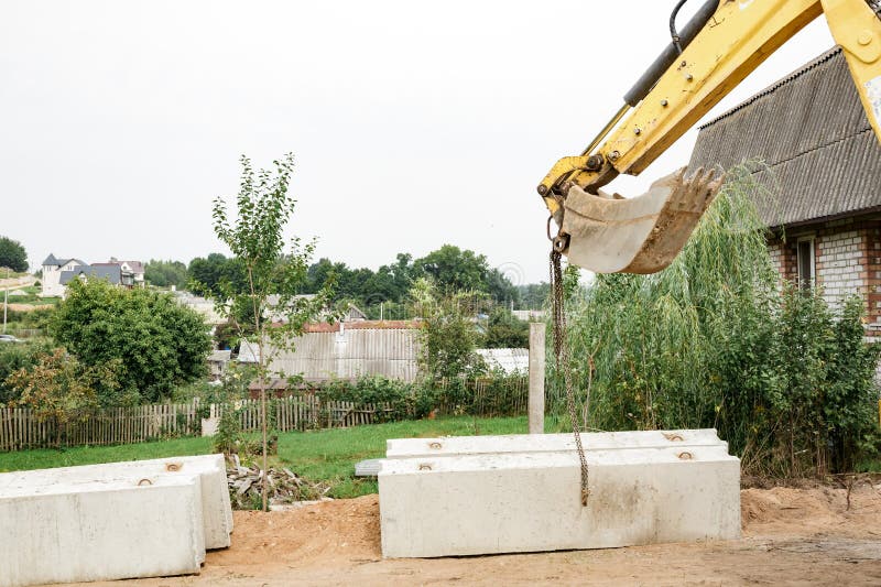 Wheel Loader. Excavator Install the Foundation Blocks into a Trench ...